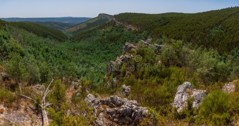 A Sweeping View of a Forested Valley with Rocky Outcrops and Distant ...