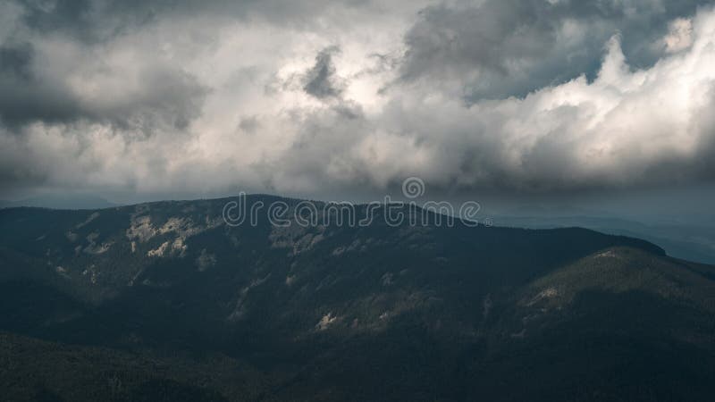 A Sweeping View of Rolling Mountain Ranges Under a Cloud-filled Sky ...