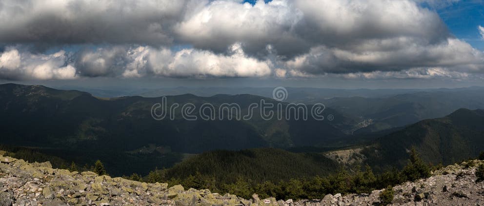 A Sweeping View of Rolling Mountain Ranges Under a Cloud-filled Sky ...
