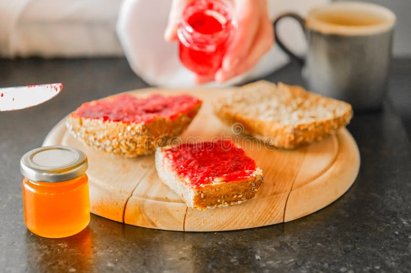 Sweet Breakfast.hands Spread Raspberry Jam on a Whole Grain Bun ...