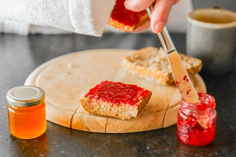Sweet Breakfast.hands Spread Raspberry Jam on a Whole Grain Bun ...