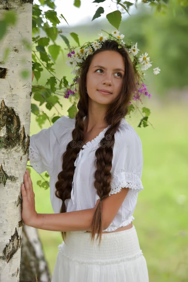 Sweet Russian Girl Girl In A White Birch In The Summer With A Wreath On Her Head And Daisies