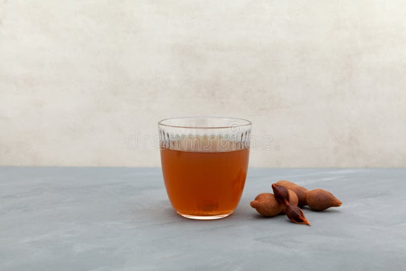 Sweet Tamarind Drink and Tamarind Fruit on Grey Table. Healthy Beverage ...