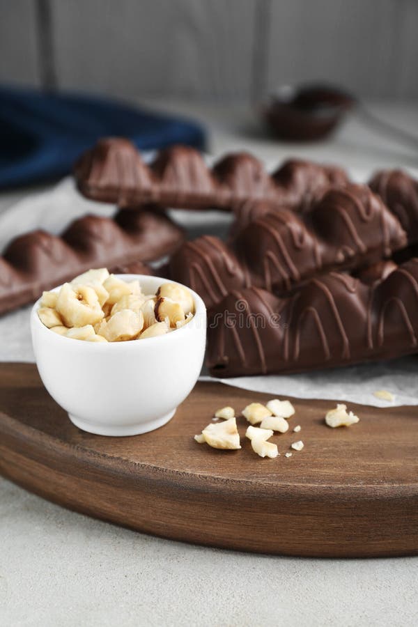 Sweet Tasty Chocolate Bars on Light Table, Focus on Bowl with Hazelnuts ...