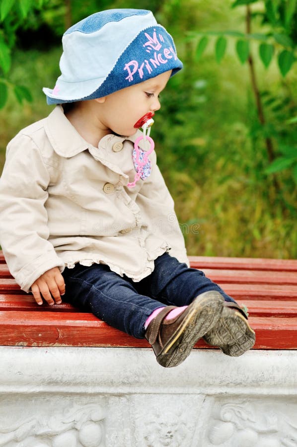 Sweet toddler on the bench stock photo. Image of pacifier - 57365866