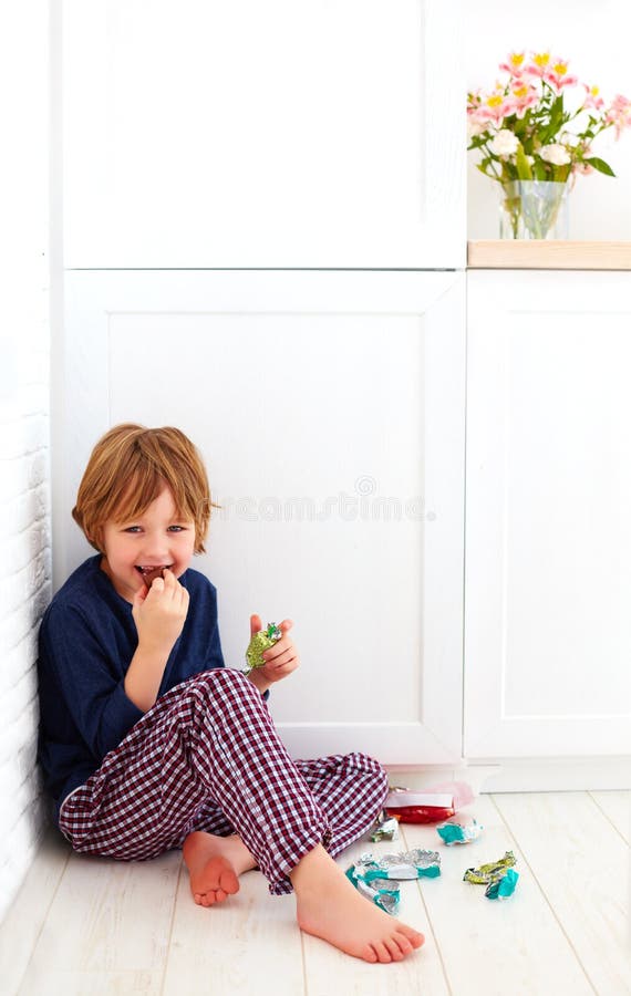 Sweet Tooth Kid Hiding in Kitchen Corner, Eating Candies Stock Image ...