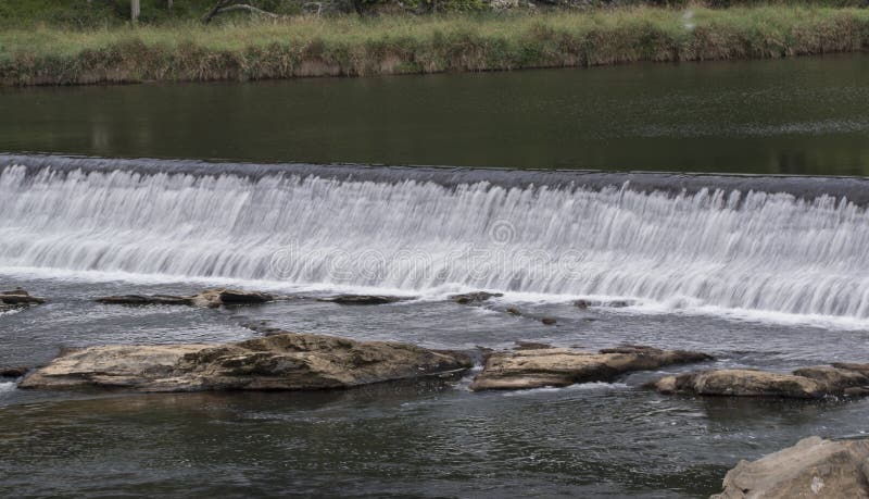 The Swift Water of the River Forms a Lot of Foam Against a Rock ...