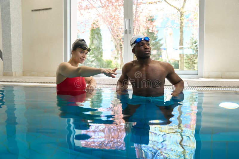 Certified Swim Instructor Instructing Beginner Swimmer in Water Stock ...