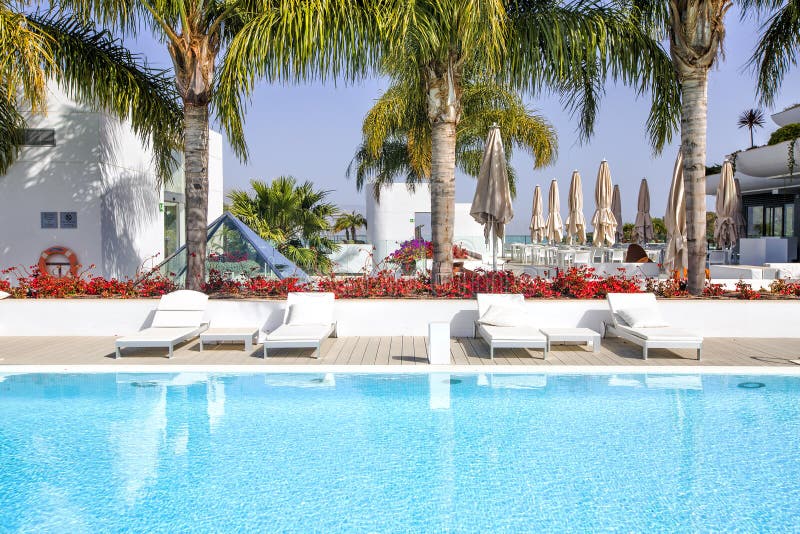 Swimming Pool Area with White Sun Beds at the Modern Resort. Stock ...