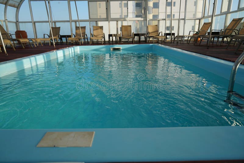 Swimming Pool Inside a Building with Lounge Chairs Stock Photo - Image ...