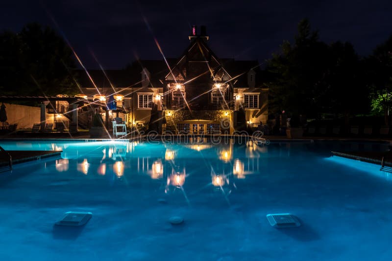 People Swimming In A Pool At Night