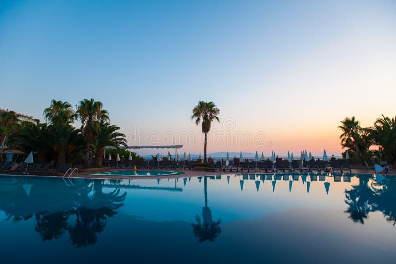 Swimming Pool with Palm Trees at Sunset. Water Reflection Stock Photo ...