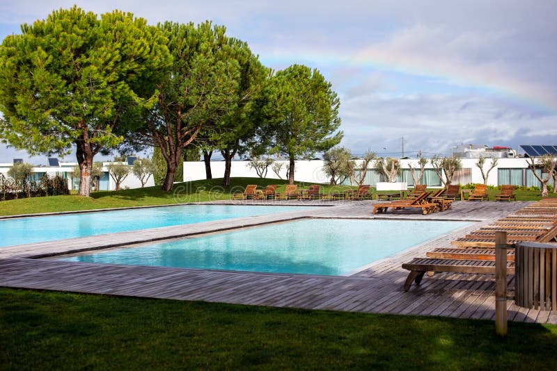 Swimming Pool with Sun Loungers and a Rainbow in the Sky Stock Photo ...