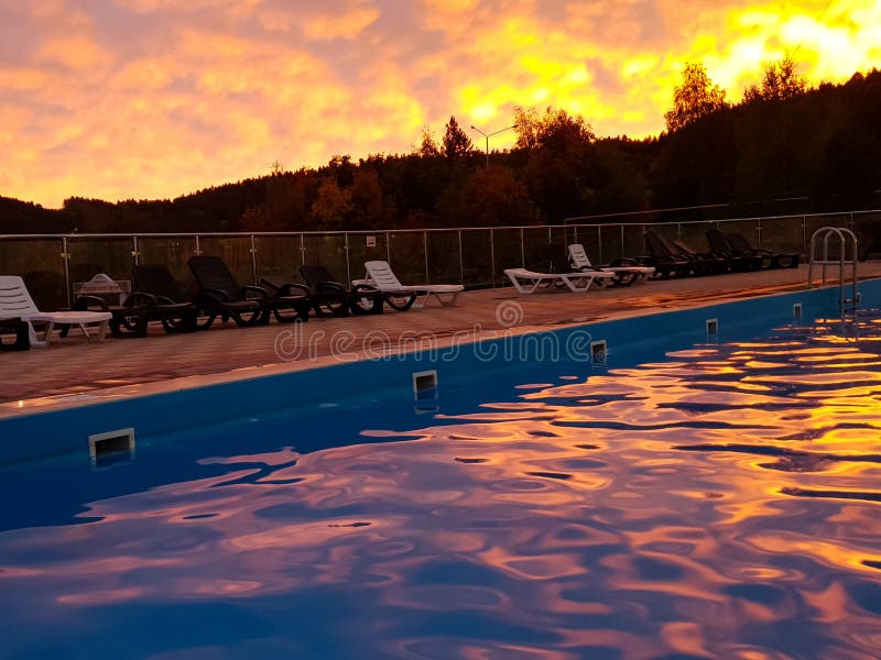 Swimming Pool with Sun Loungers at Sunset Stock Photo - Image of dusk ...