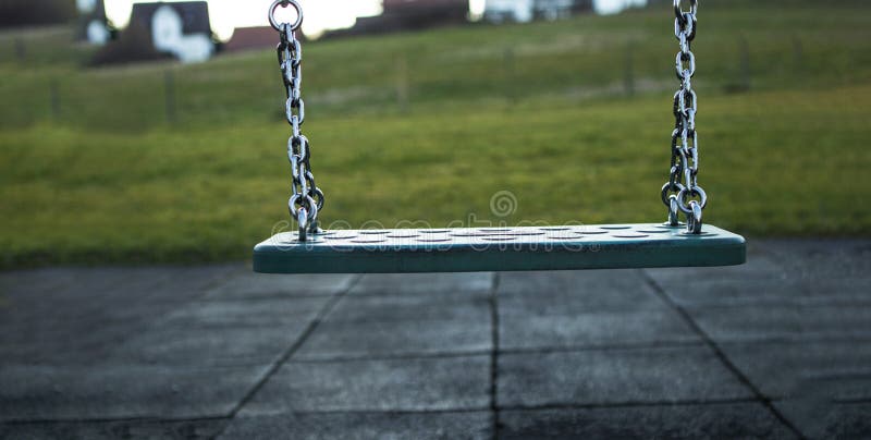 Swing with Chain Over Black Floor Out in the Playground Stock Photo ...