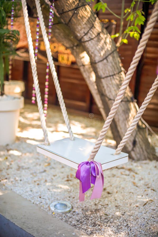 Swing with a purple bow stock image. Image of flower - 75163781