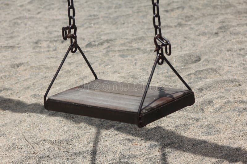 A Swing with a Seat Made of Wood and a Rope Handle Made of Iron Chains ...