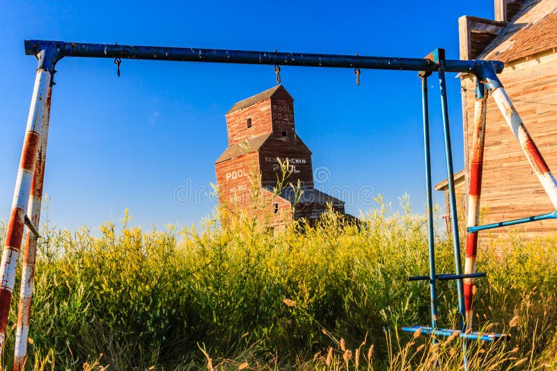 A Swing Set is Hanging from a Building with a Large Grain Silo in the ...