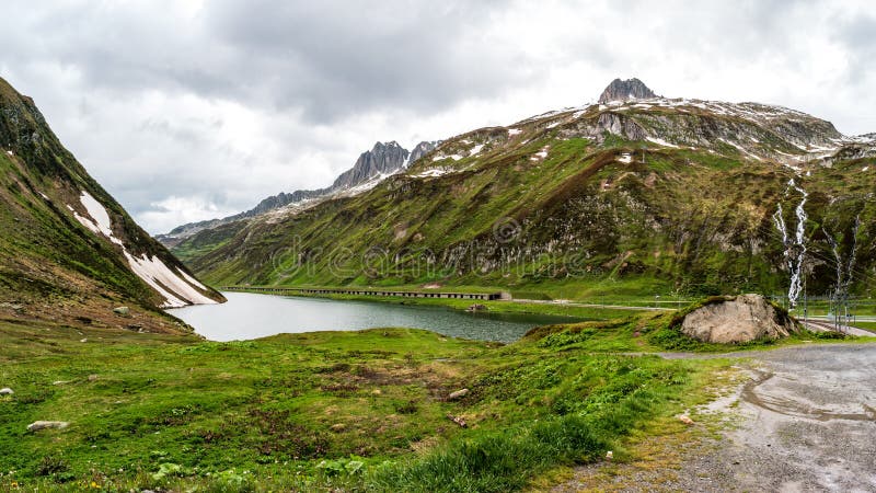 Swiss Alps Mountain Pass Panoramic Scene with Lake and Cloudy Dramatic ...