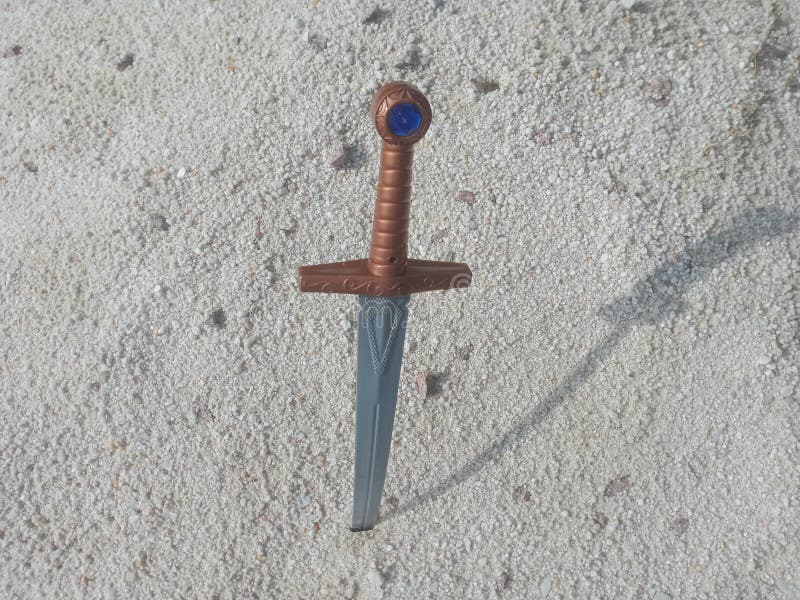 Sword stuck on the ground stock photo. Image of people - 243523998