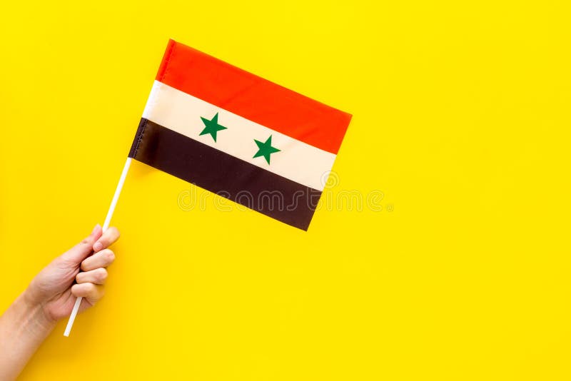 Syrian Flag Concept. Hand Hold Small Flag on Yellow Background Top View ...