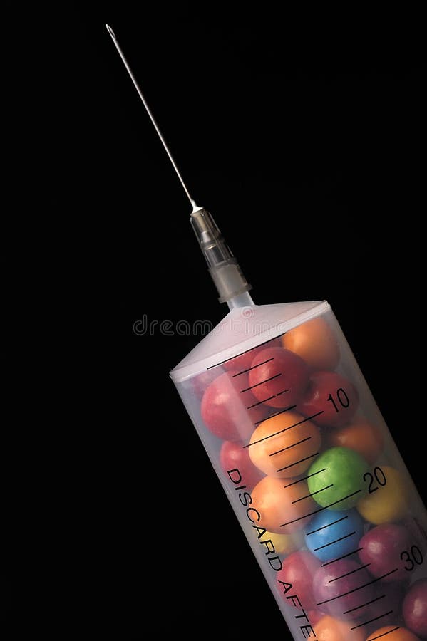 A Syringe Filled with Candy on Black Back Stock Photo - Image of ...