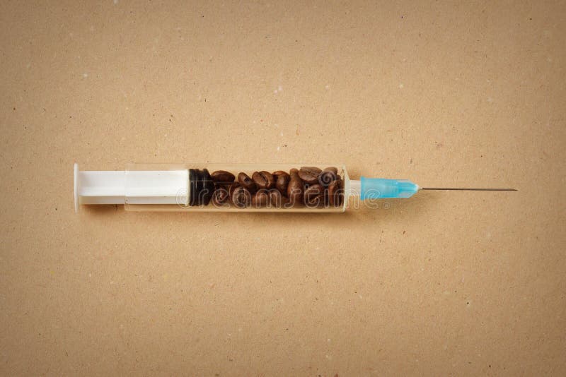 Syringe Filled with Coffee Beans on Recyled Paper Background Stock ...
