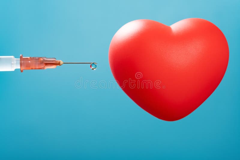 A Syringe and a Heart Model on Blue Background Stock Image - Image of ...