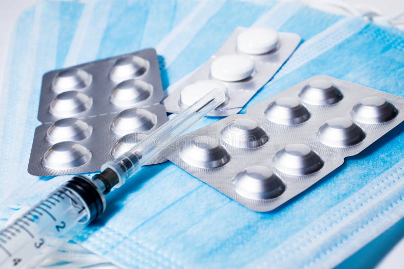 Syringe for Injection and Silver Packaging with Tablets on the ...