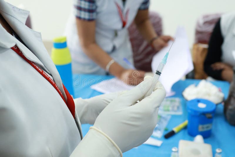 Syringe with Needle Containing a Vaccine Shot in a Gloved Hand Stock ...