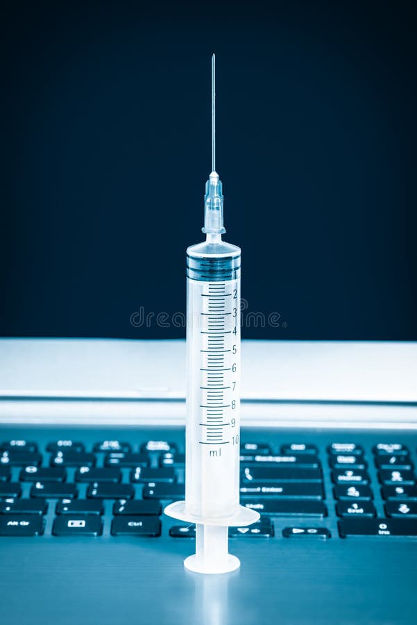 Syringe Next To a Laptop Computer Toned in Blue Stock Image - Image of ...