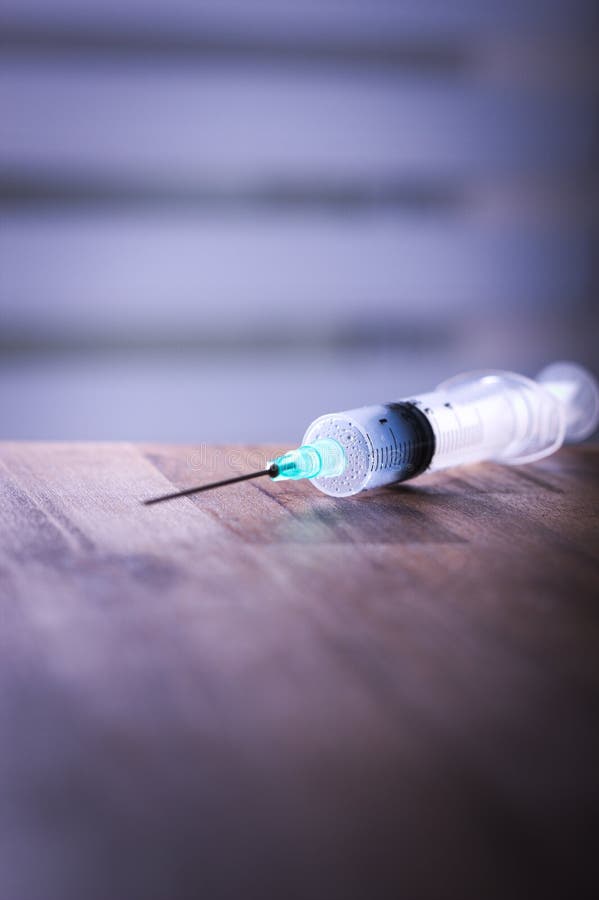 Syringe on table with blur stock photo. Image of equipment - 99818242