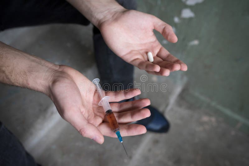 Syringe and Tablet in the Hands of an Addict, Close-up. Addiction ...