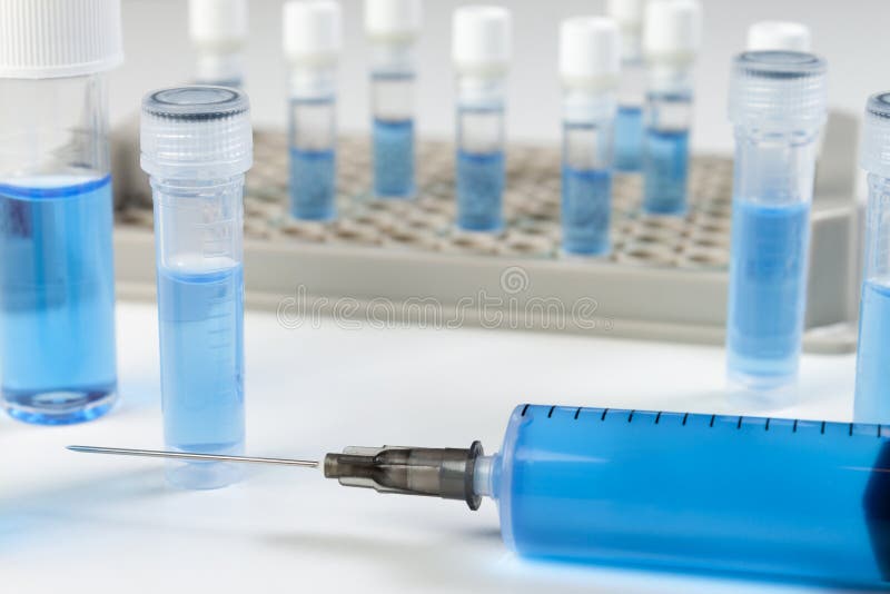 Syringe and Vials Containing Blue Fluid on Bench Stock Image - Image of ...