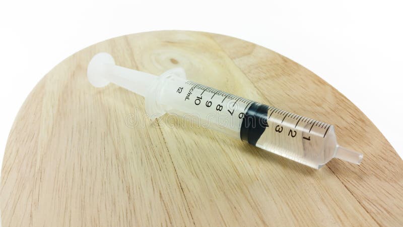 Syringe on wood plate stock photo. Image of needle, plastic - 61023258