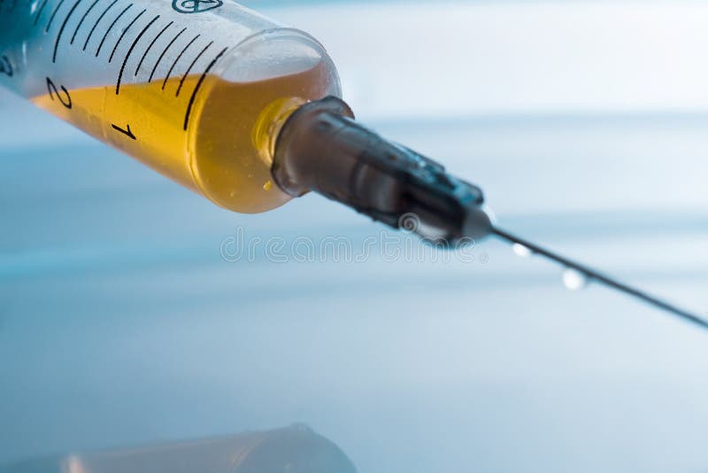 Syringe with yellow liquid stock photo. Image of instrument - 12845220