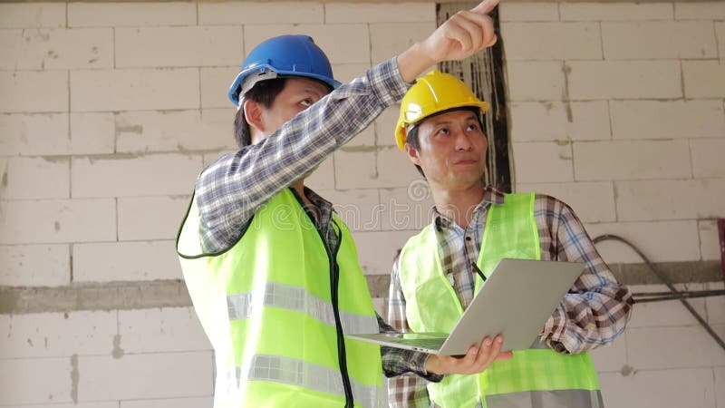 System Engineer and Construction Foreman Holding a Laptop Check the ...