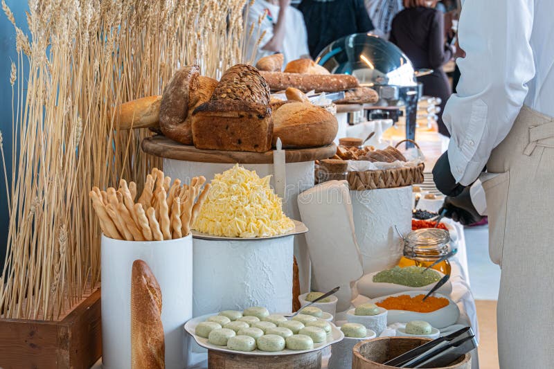 Table with Assorted Breads, Pastries, and Cheeses Buffet Setup with ...