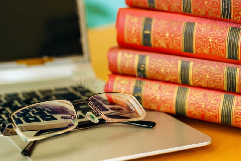 On the Table are Books in a Red Cover and a Laptop. Stock Image - Image ...
