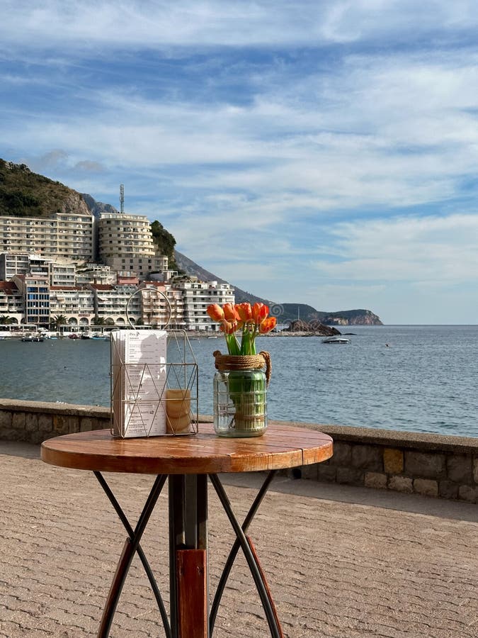 A Table with a Bouquet of Tulips and a Stack of Menus on the Embankment ...