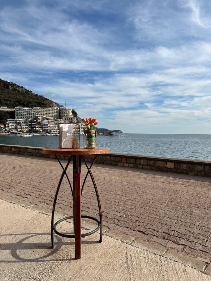 A Table with a Bouquet of Tulips and a Stack of Menus on the Embankment ...