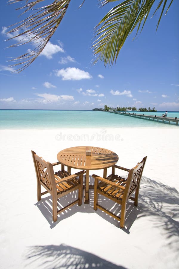 Table and chairs on beach stock image. Image of blue, palm - 4958145