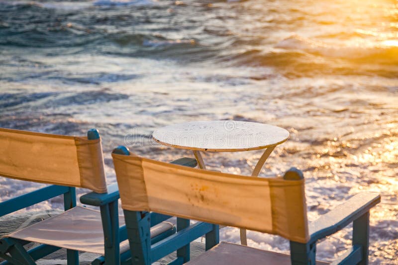 Table and Chairs Near the Waves at Sunset - Beach Holiday Stock Photo ...