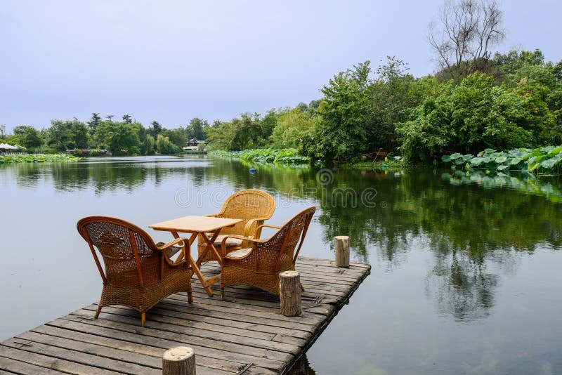 Table and Chairs on Planked Platform Over Lake Stock Image - Image of ...