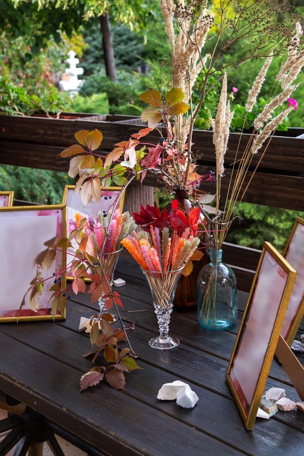 Table with Decorative Wheels, Lined with Bottles with Leaves and Reeds ...