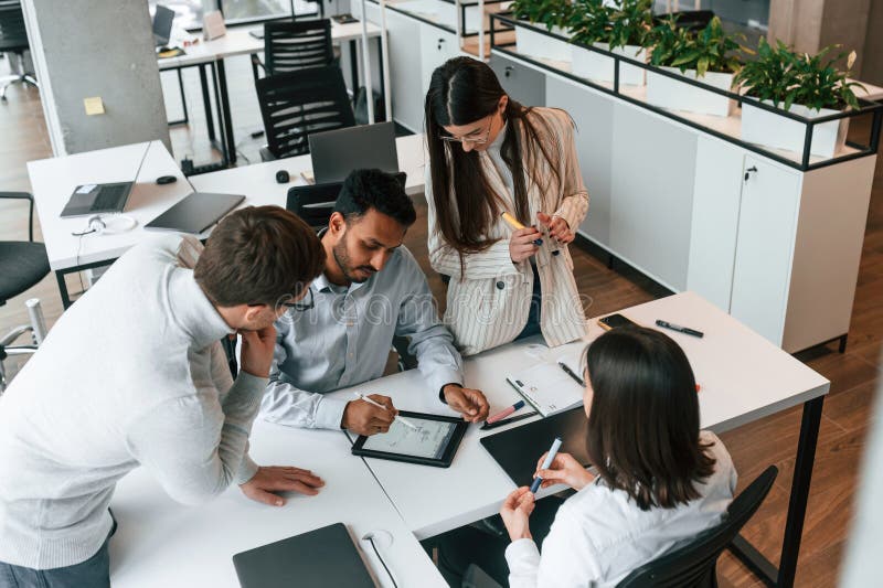 By the Table. Four People are Working in the Office Together Stock ...