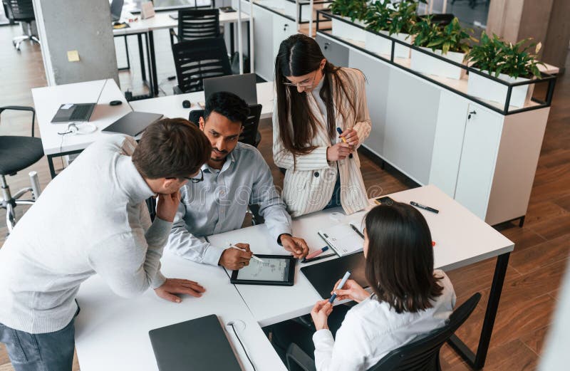 By the Table. Four People are Working in the Office Together Stock ...