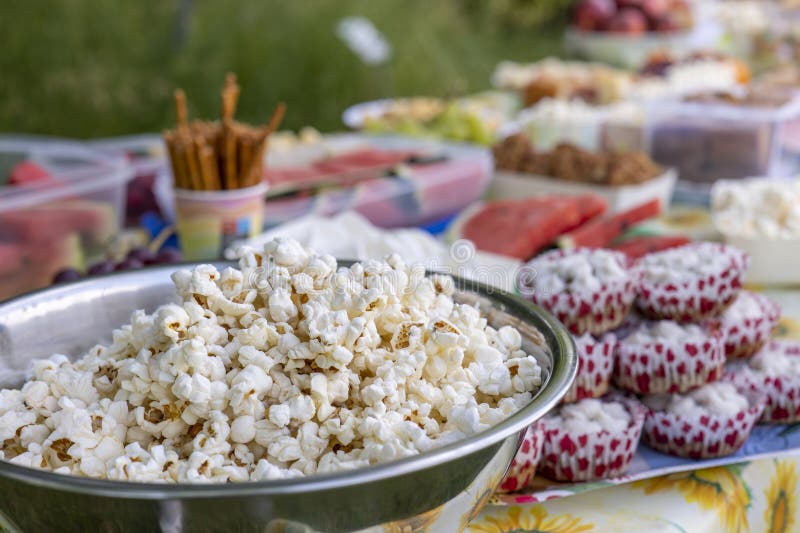 A Table Full of Snacks. a Bowl Full of Corn in the Foreground. Outdoor ...