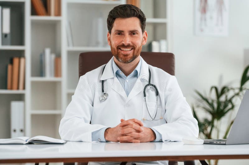 By the Table with Laptop. Doctor in Formal Clothes is Working in the ...