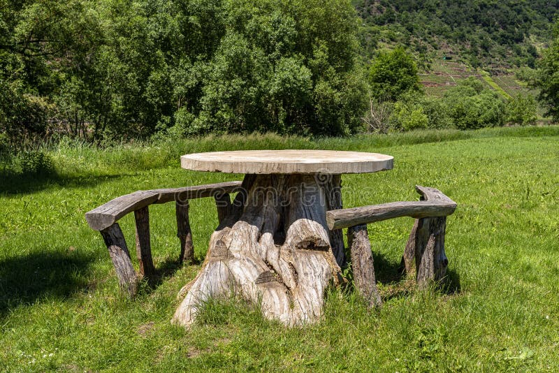 A Table Made of a Tree Trunk with a Concrete Top and Wooden Seats ...